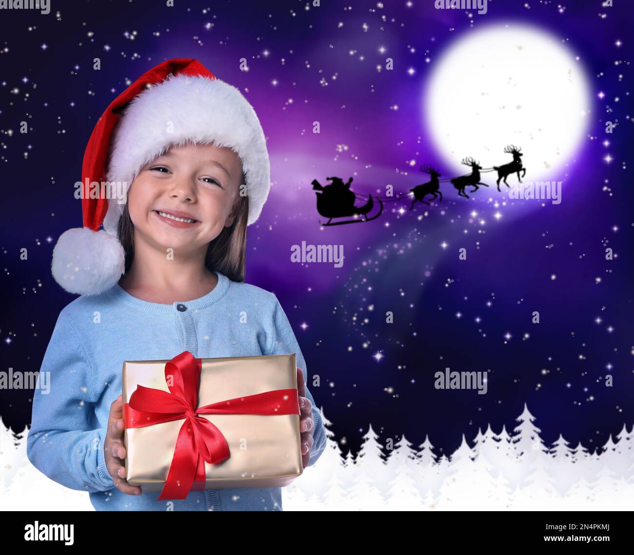 Cute little child and Santa Claus flying in his sleigh against moon sky ...
