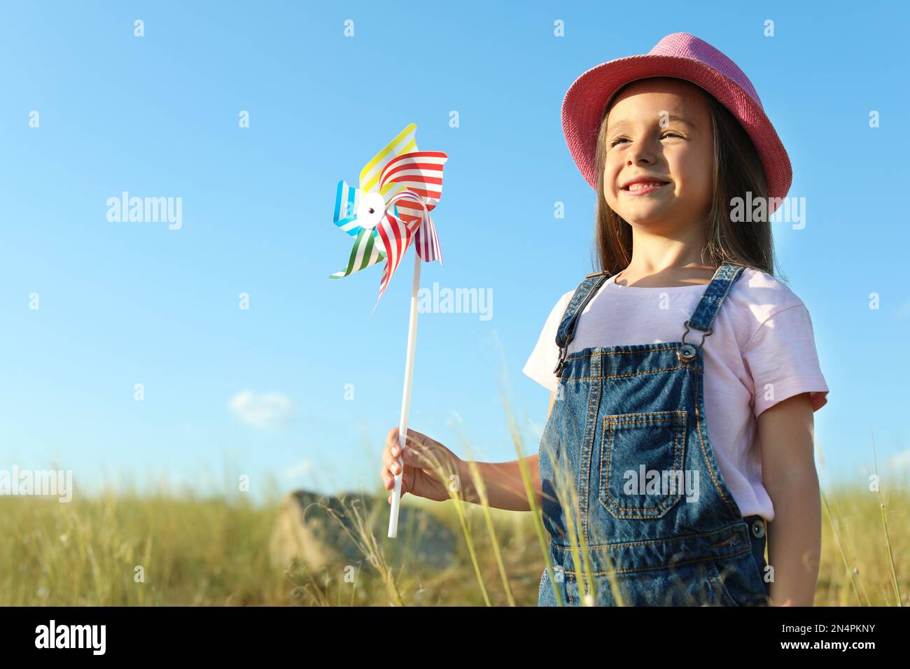 Cute little girl with pinwheel outdoors. Child spending time in nature ...