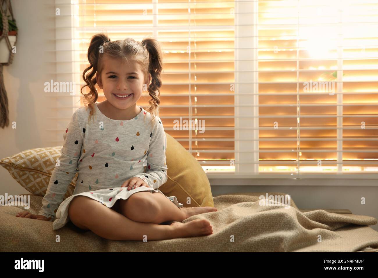 Portrait of cute little girl near window at home Stock Photo - Alamy