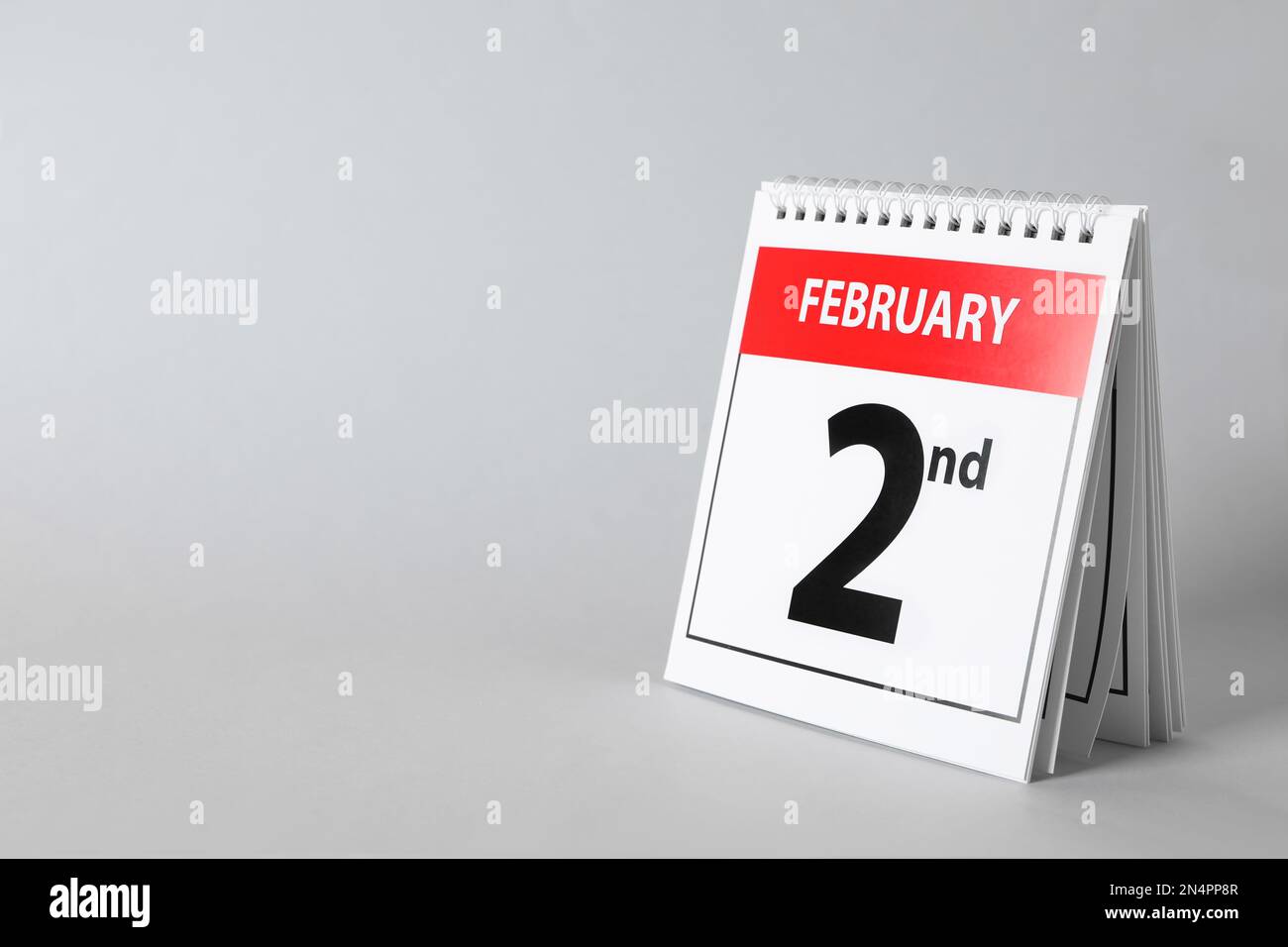 Calendar with date February 2nd on light background, space for text ...