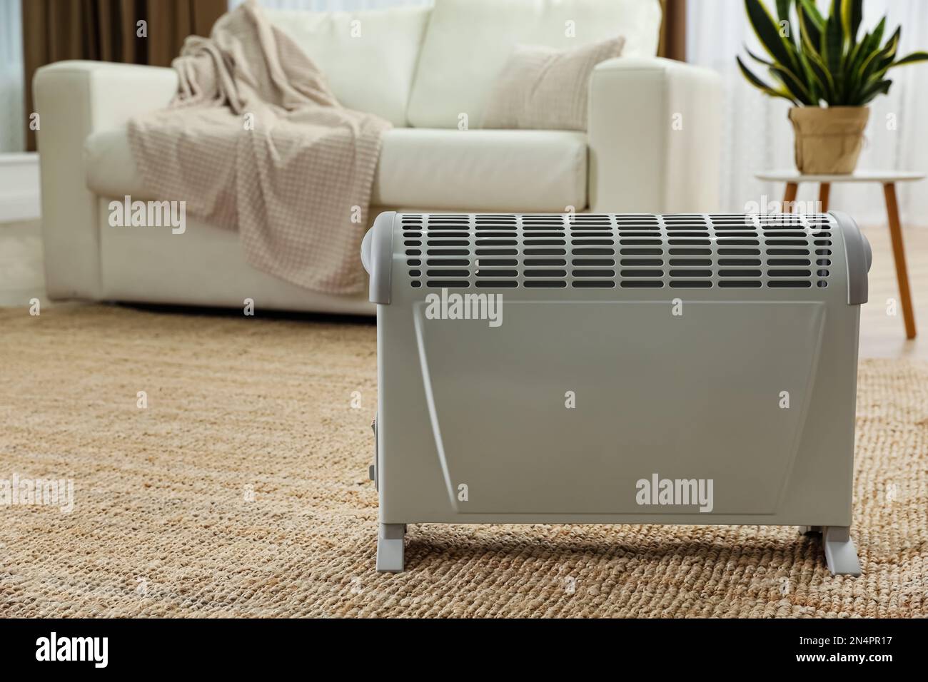 Modern electric convection heater on floor at home. Space for text ...
