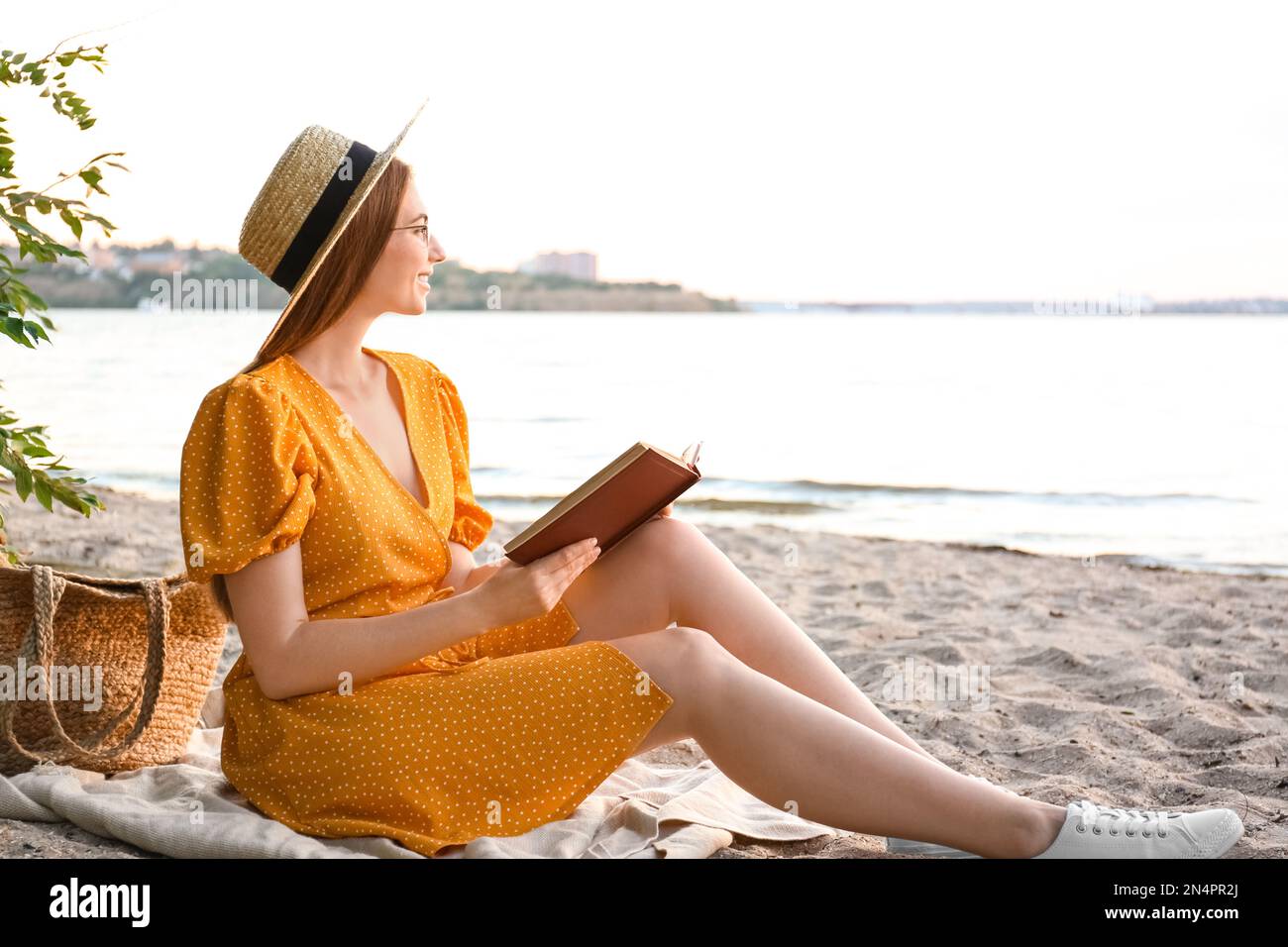 Woman reading book near beach hi-res stock photography and images - Alamy