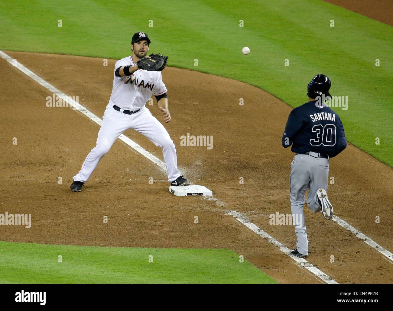 Miami Marlins first baseman Garrett Jones, left, waits for the throw as ...