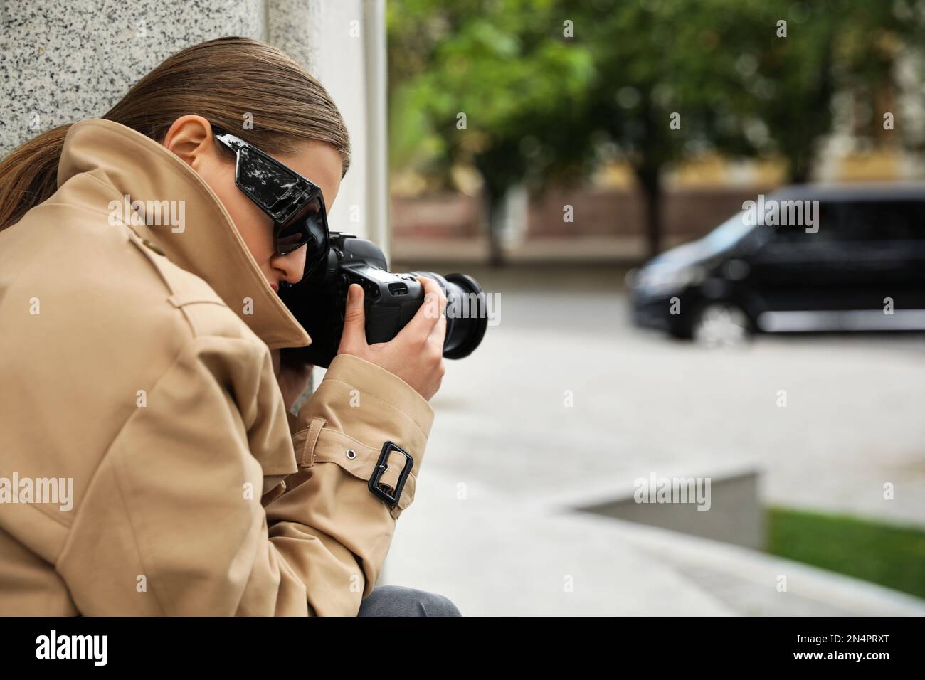 Private detective with modern camera spying on city street Stock Photo ...