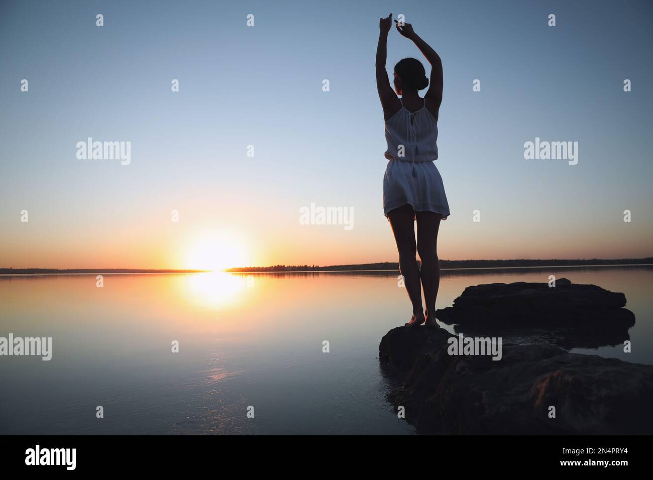 Woman near river on sunset. Healing concept Stock Photo - Alamy
