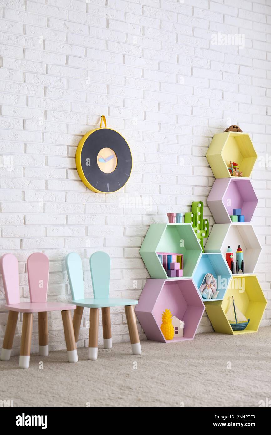 Child room interior with colorful shelves near brick wall Stock Photo ...