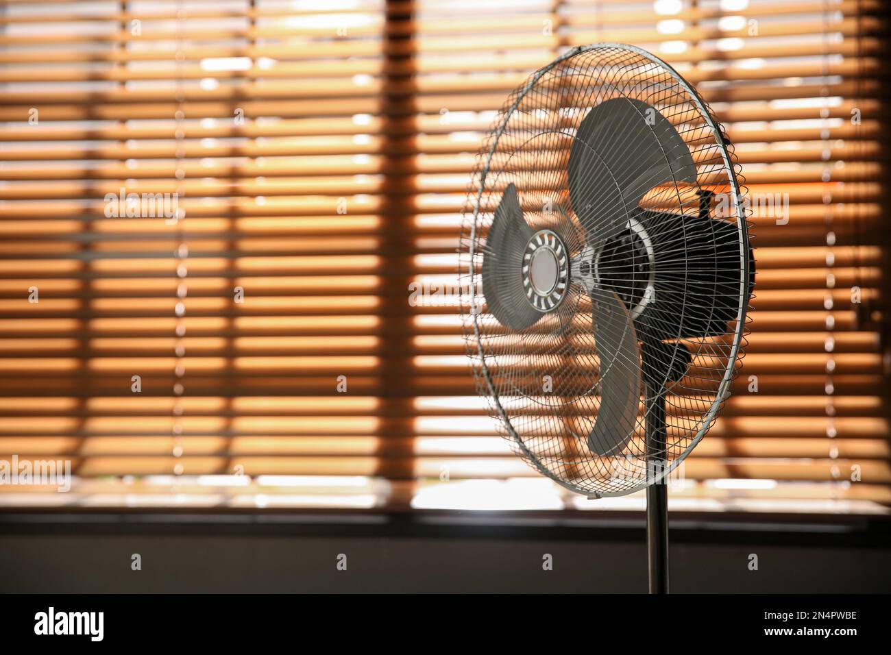 Modern electric fan near window indoors. Space for text Stock Photo - Alamy