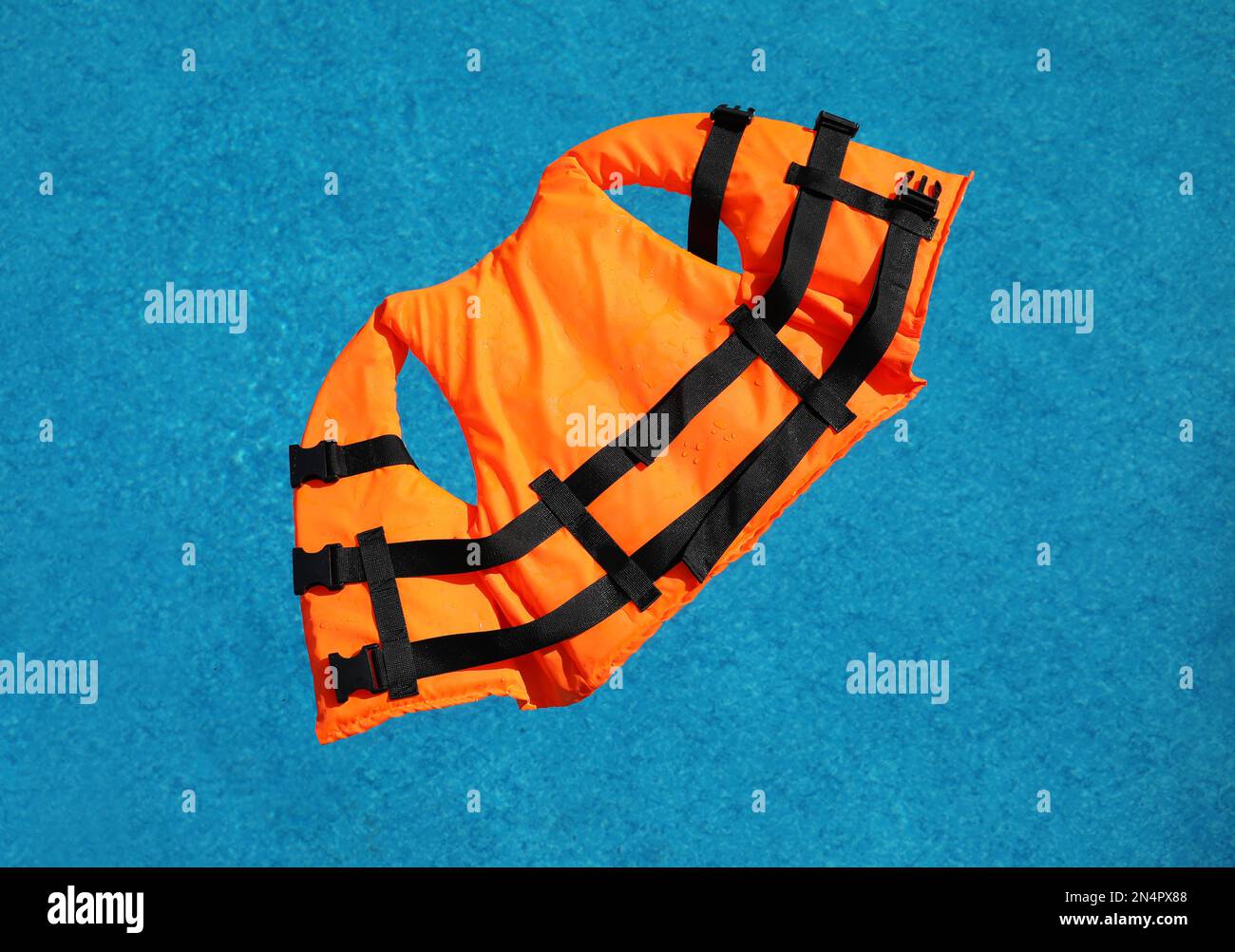 Bright orange life jacket floating in swimming pool, top view Stock ...
