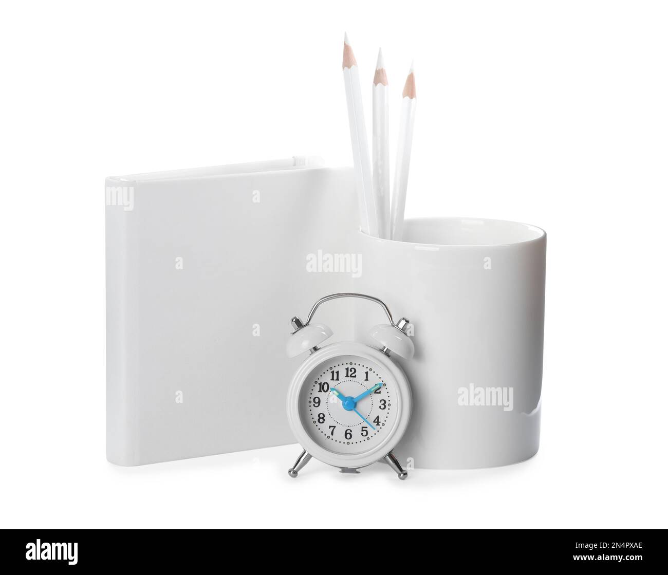 Holder with pencils, book and alarm clock on white background Stock ...