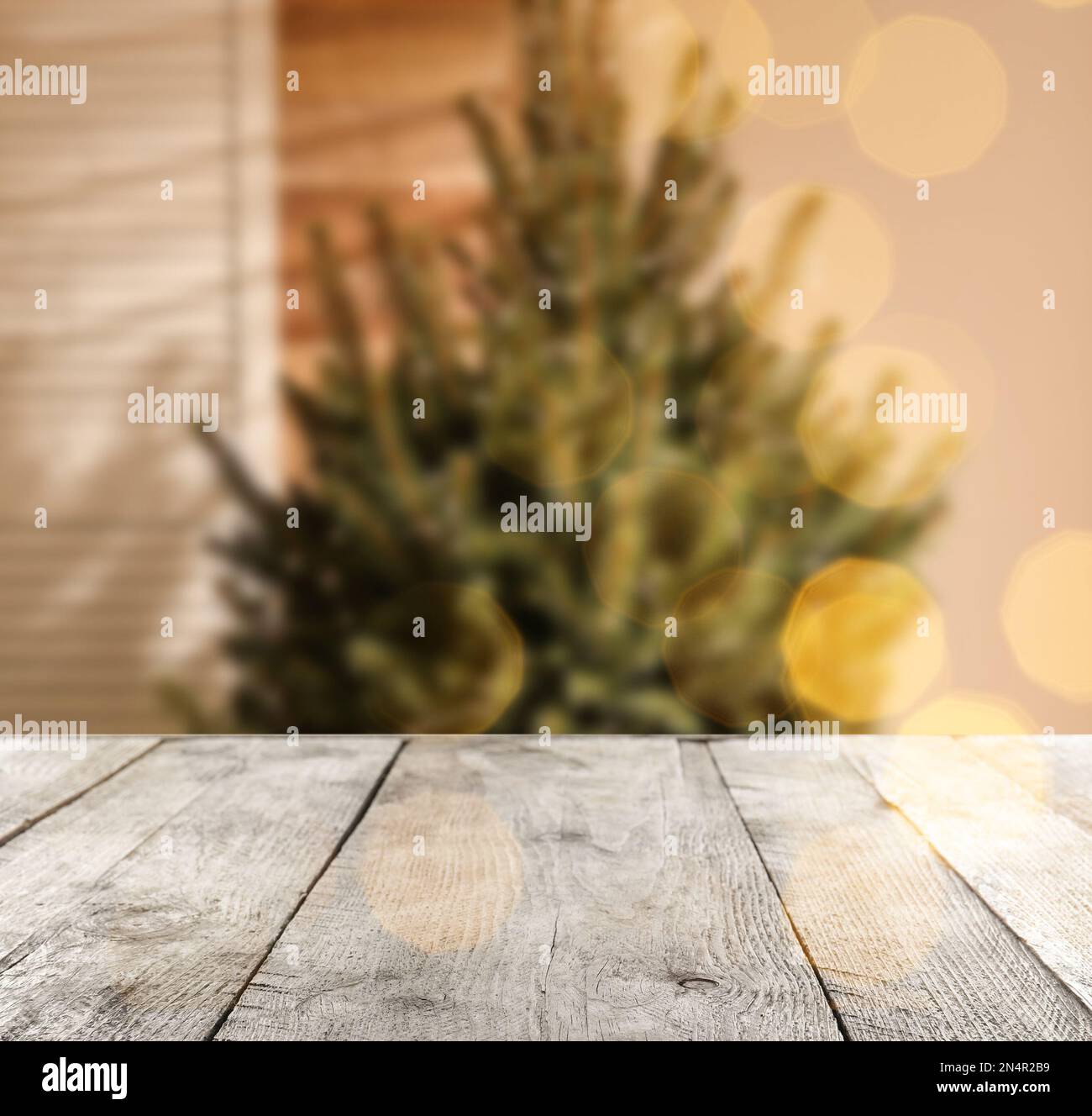 Empty wooden surface and blurred view of Christmas tree in room, space ...