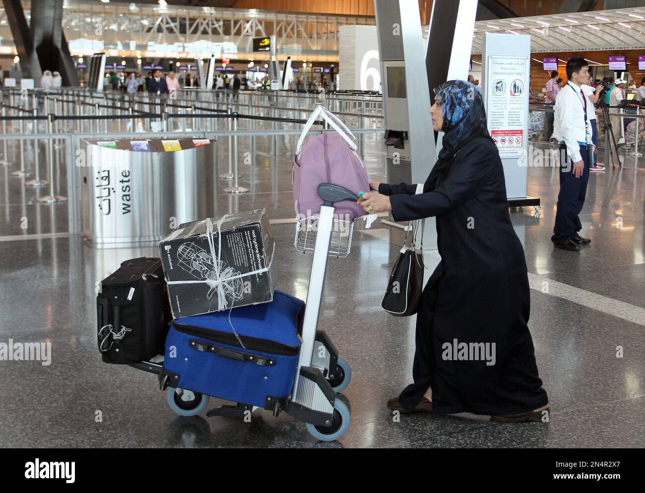 A Qatari passenger walks to the check-in area inside the new Hamad ...