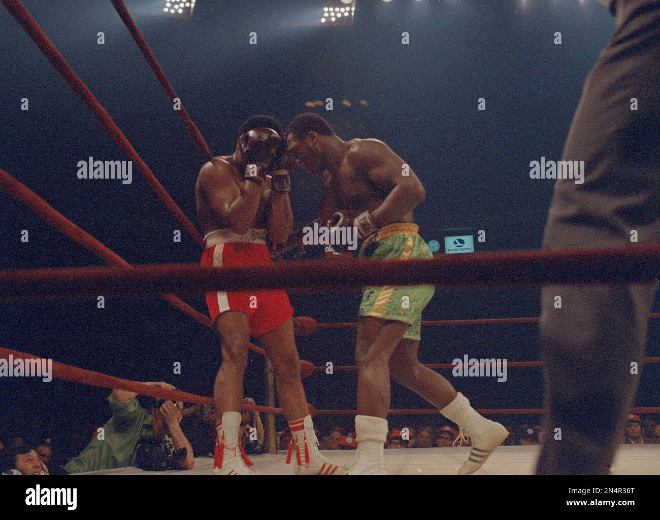 Muhammad Ali, red trunks, and Joe Frazier, green trunks, are shown ...