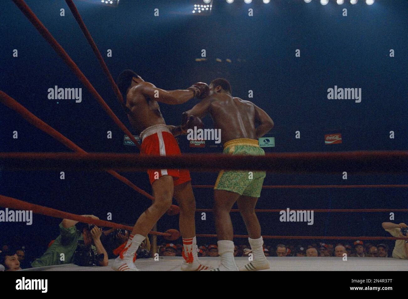 Muhammad Ali, red trunks, and Joe Frazier, green trunks, are shown ...