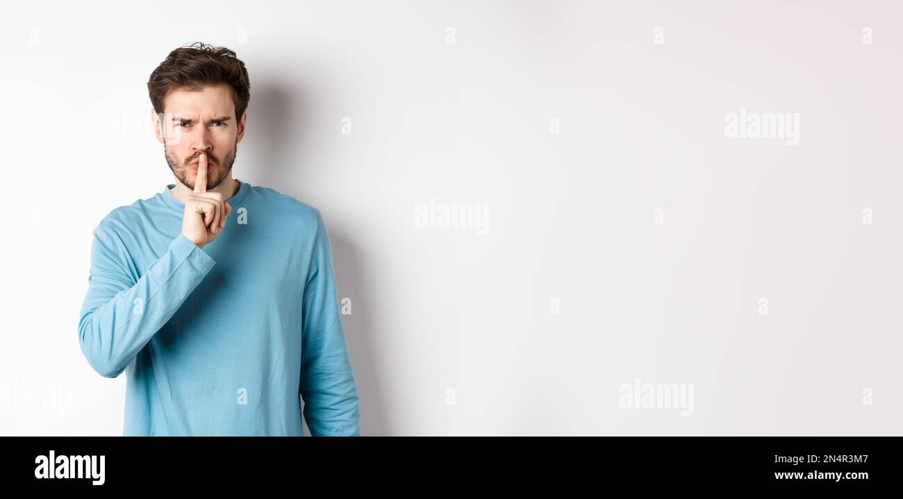 Angry man shushing at camera and telling to be quiet, frowning upset ...