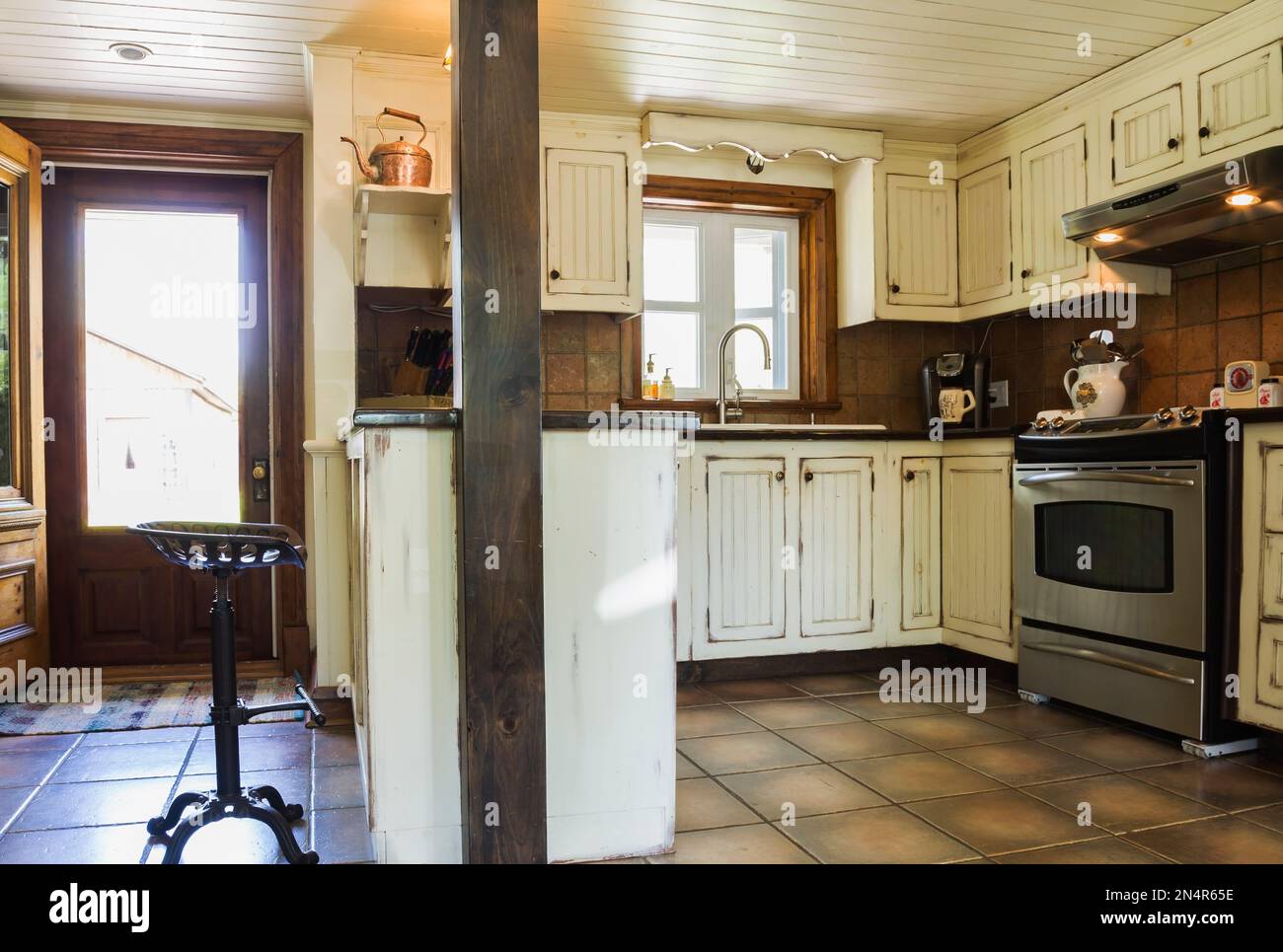 Kitchen with cream coloured antique finish wooden cabinets, ceramic ...