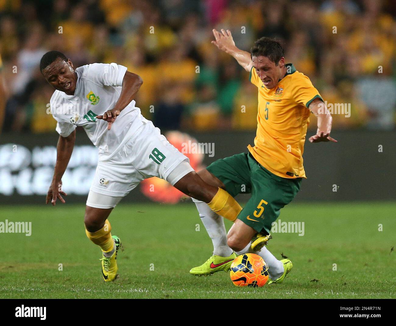 Australia's Mark Milligan, right, and South Africa's Thuso Phala fight ...
