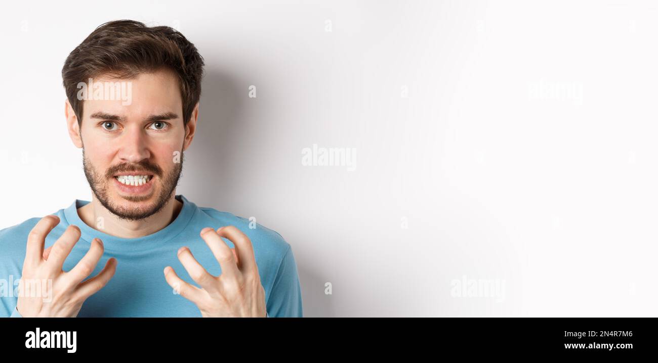 Close up of angry young man with beard, shaking hands mad, squeeze ...