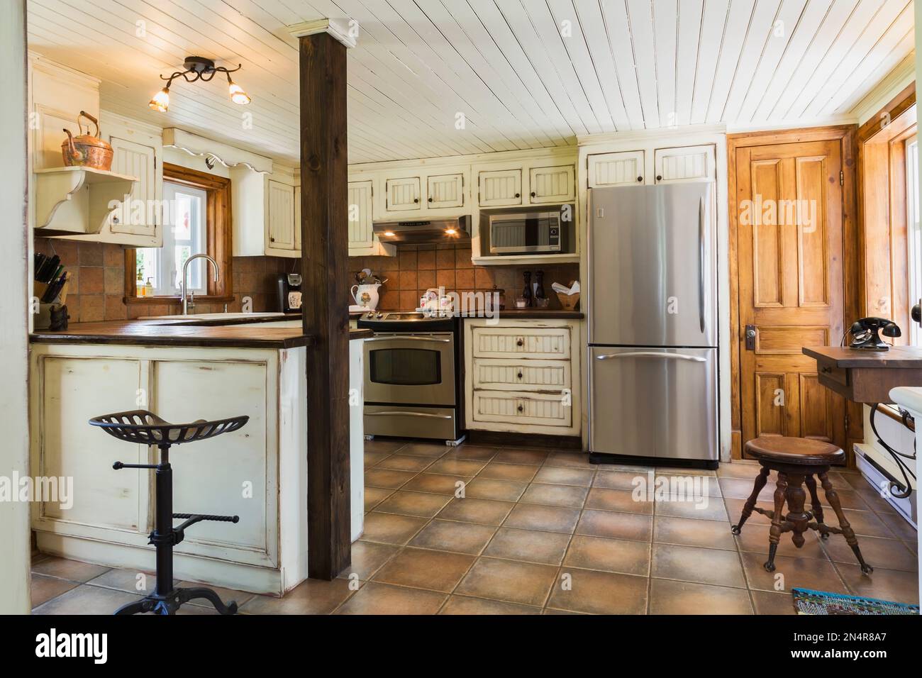 Kitchen with cream coloured antique finish wooden cabinets, ceramic ...