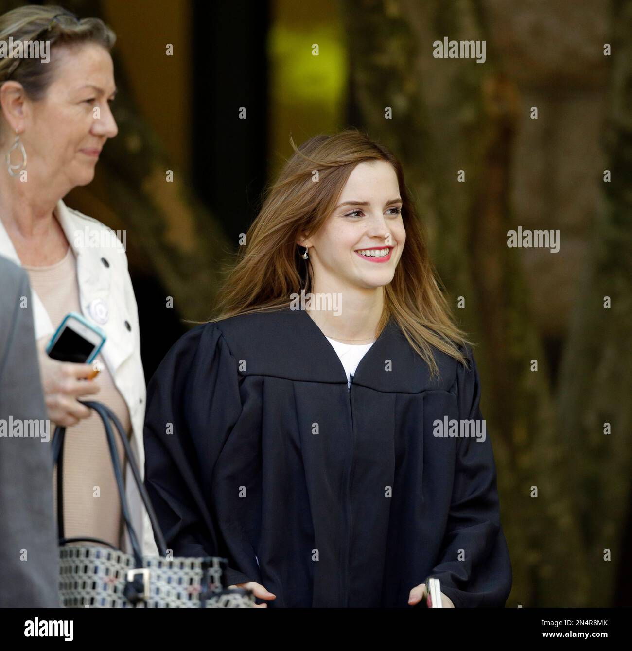 Actress Emma Watson, right, walks between buildings following ...