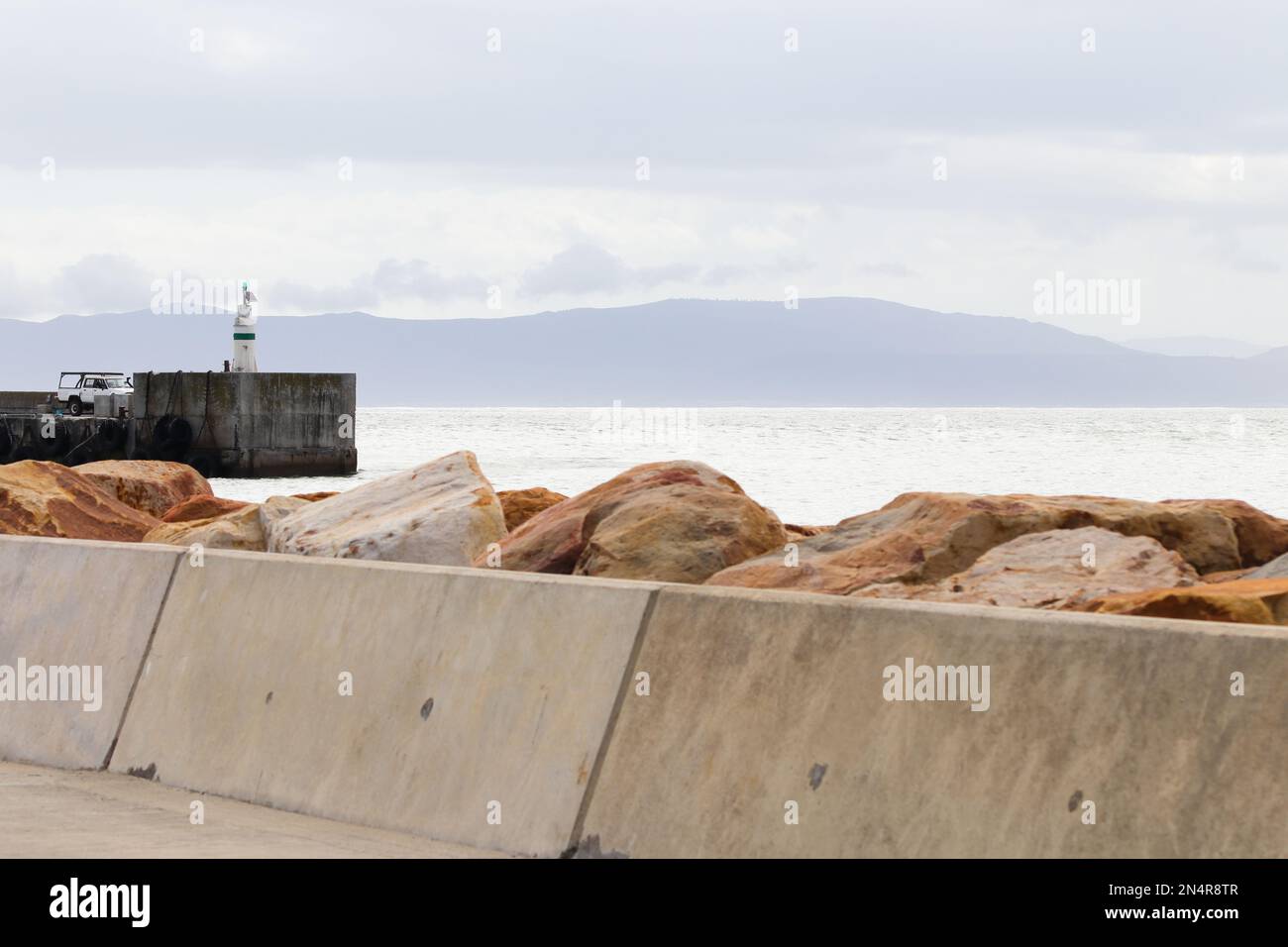 Harbor Quay With Light Beacon Overlooking Coastal Bay Stock Photo - Alamy