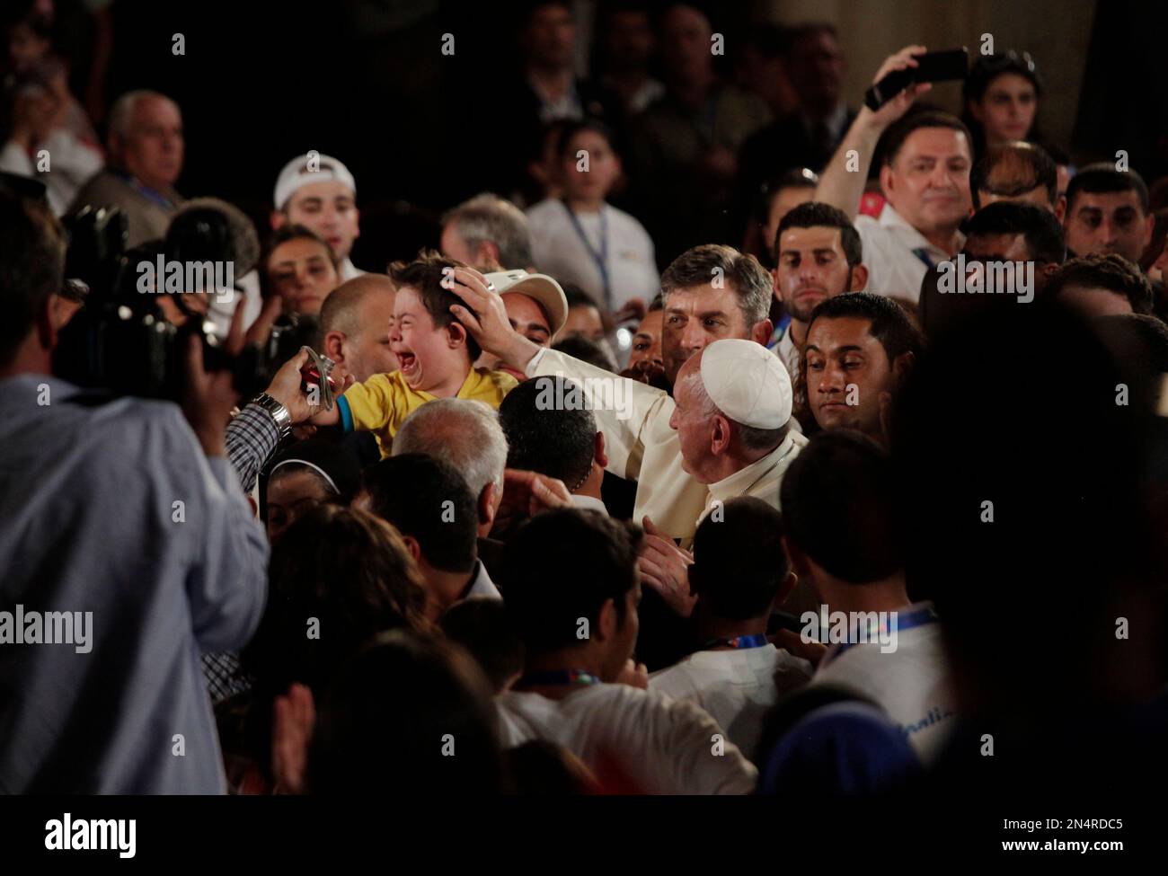 Pope Francis lays his hand on an ill boy for blessing, after finishing ...
