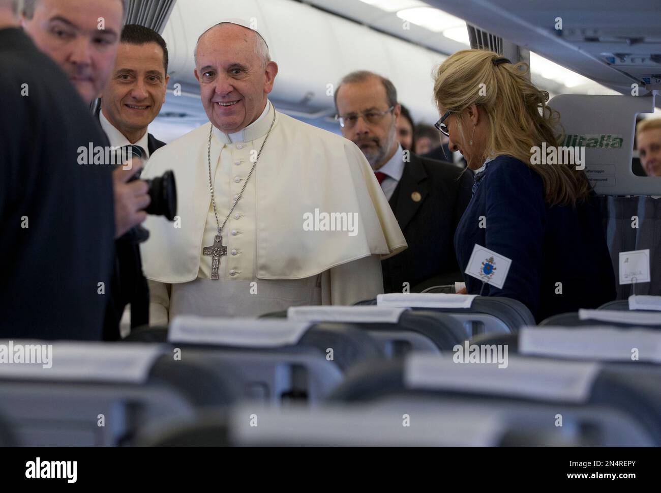 Pope Francis walks over to greets journalists aboard the papal flight ...