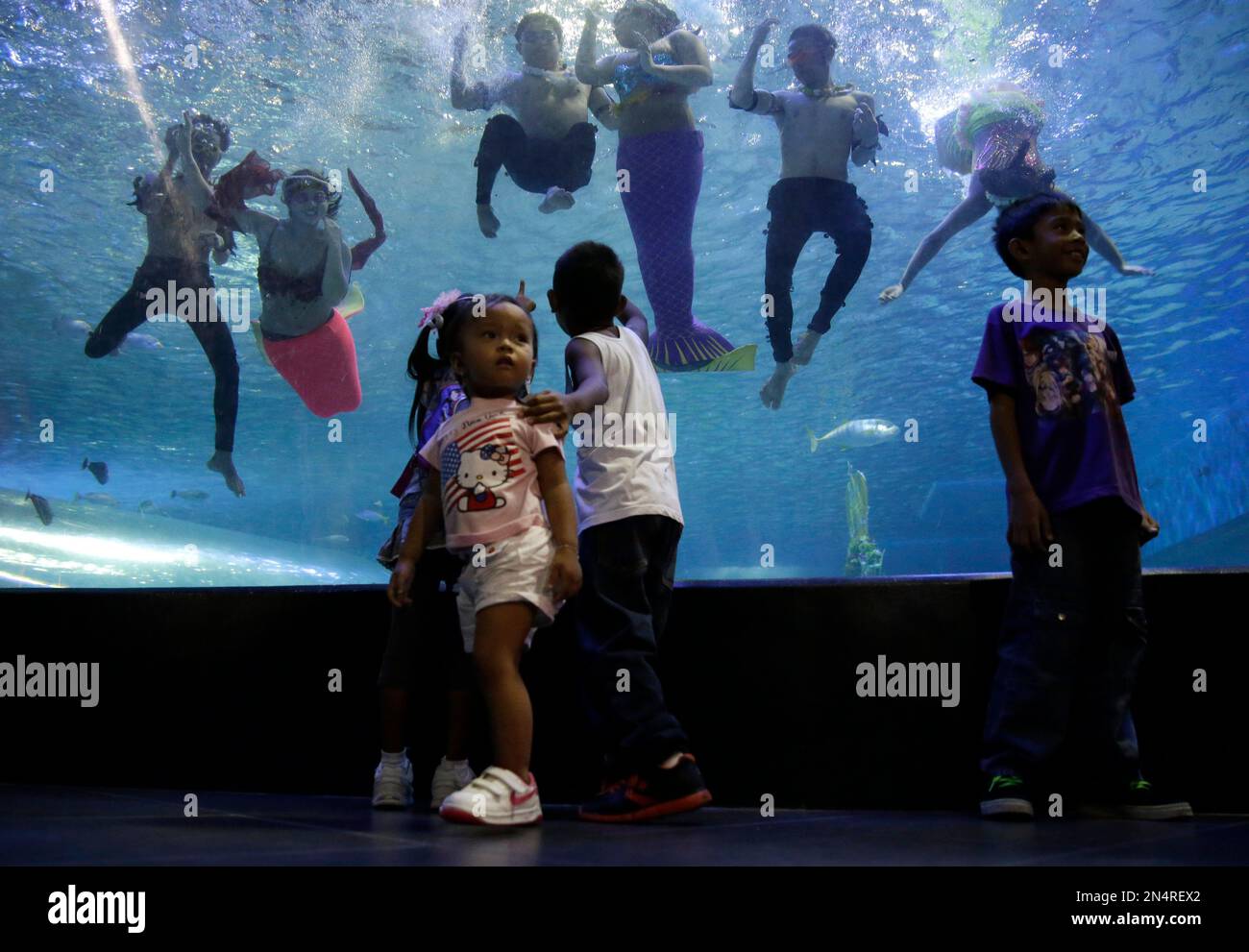 Divers dressed as mermaids interact with the crowd following a ...