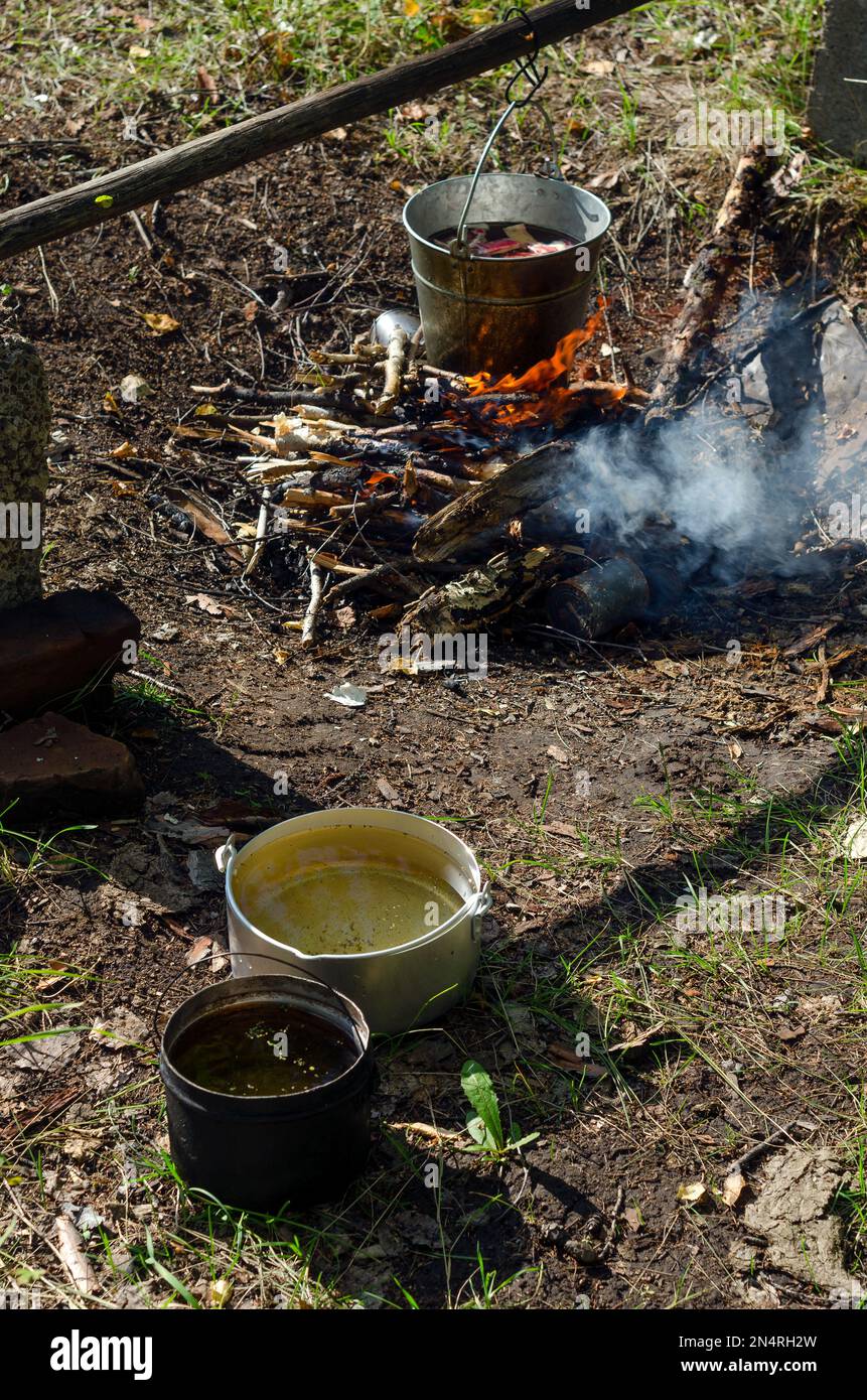 Pieces of meat float in a bucket on a campfire in the wild North of ...