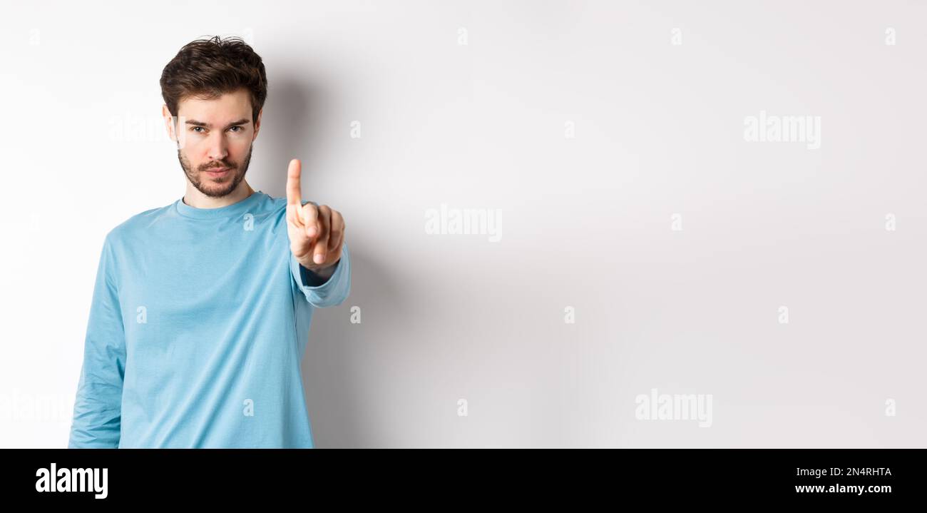 Image of serious young man with beard, shaking finger in disapproval ...