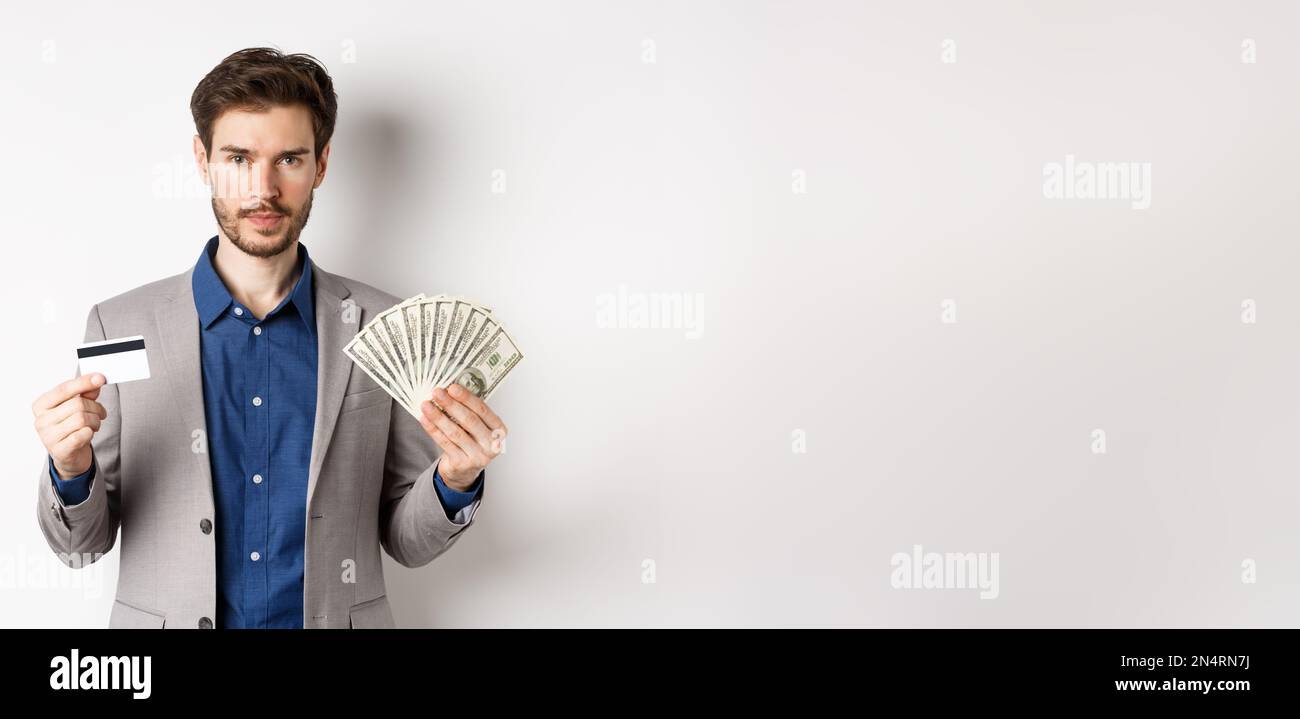 Successful businessman making money, standing in suit with dollar bills ...