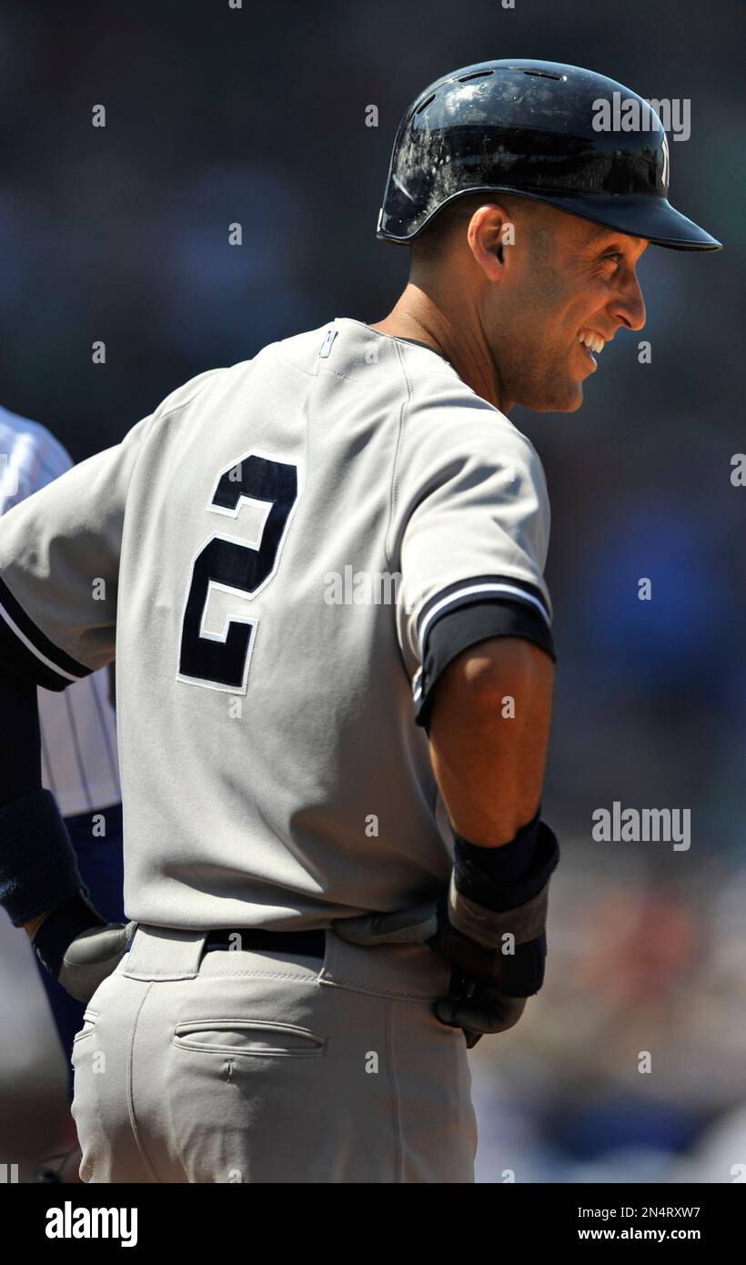 New York Yankees' Derek Jeter smiles at first base after hitting a ...