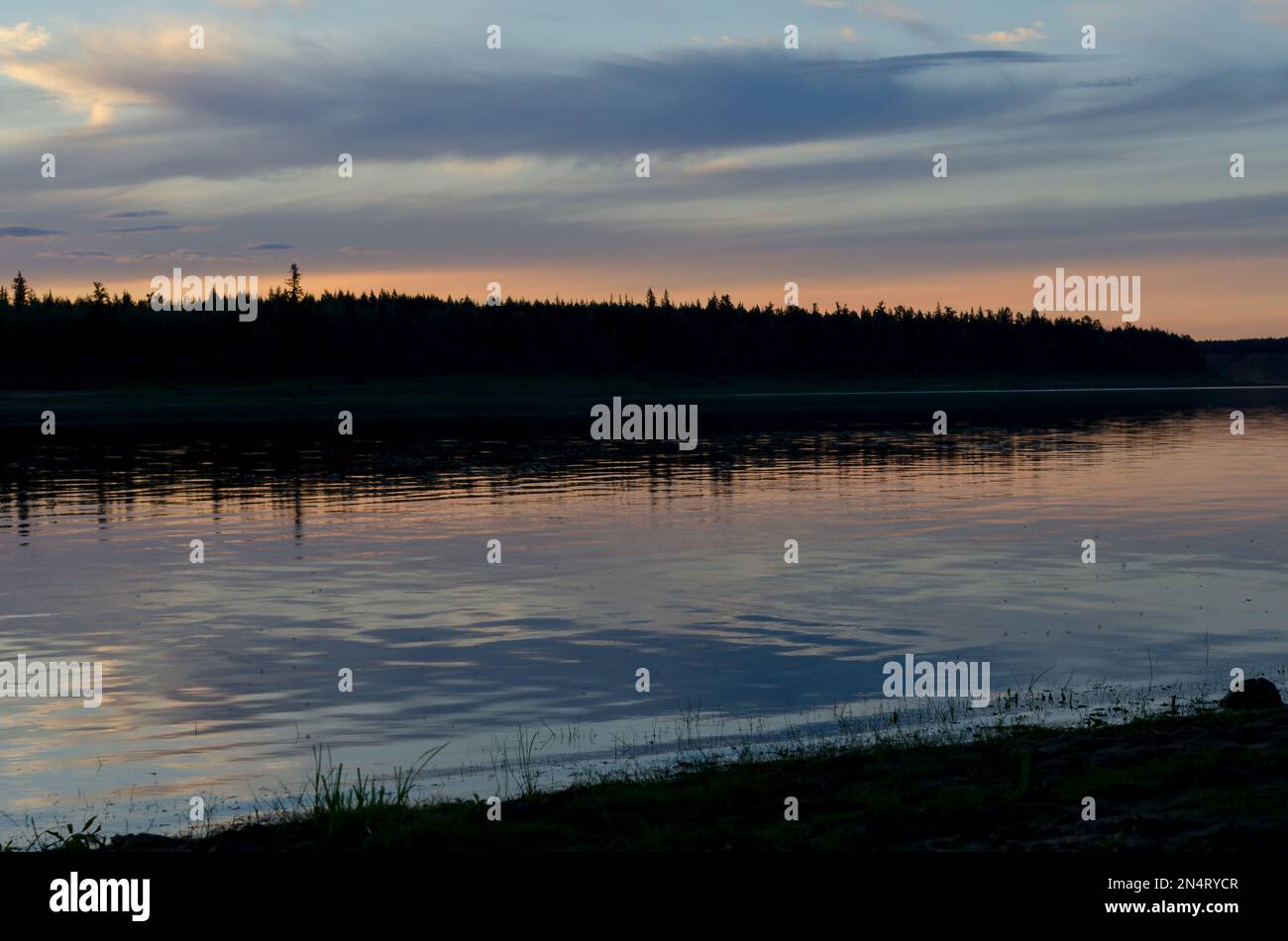 Bright blue sunset on the banks of the Northern river Viluy under the ...