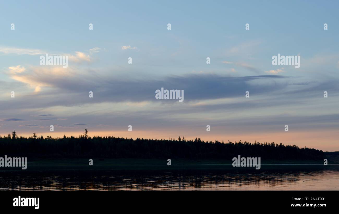 Bright blue sunset on the banks of the Northern river Viluy under the ...
