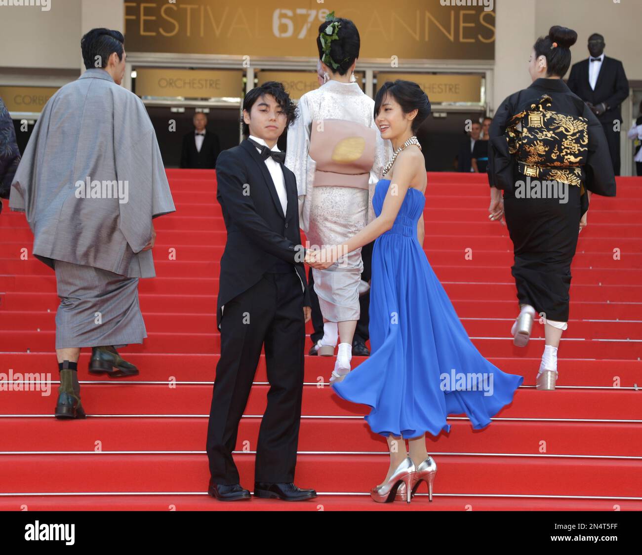 Actor Nijiro Murakami, center left, holds the hand of actress Jun Yoshinaga as they arrive for ...