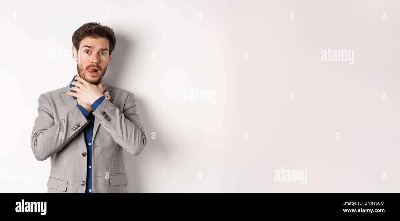 Distressed young man in business suit strangle himself and showing ...