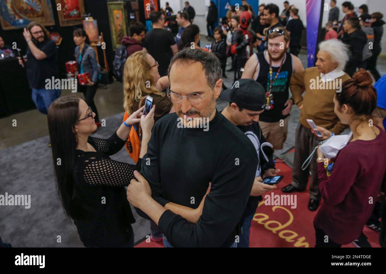 Visitors gather around the Madame Tussauds exhibit of wax figures including Steve Jobs, during ...