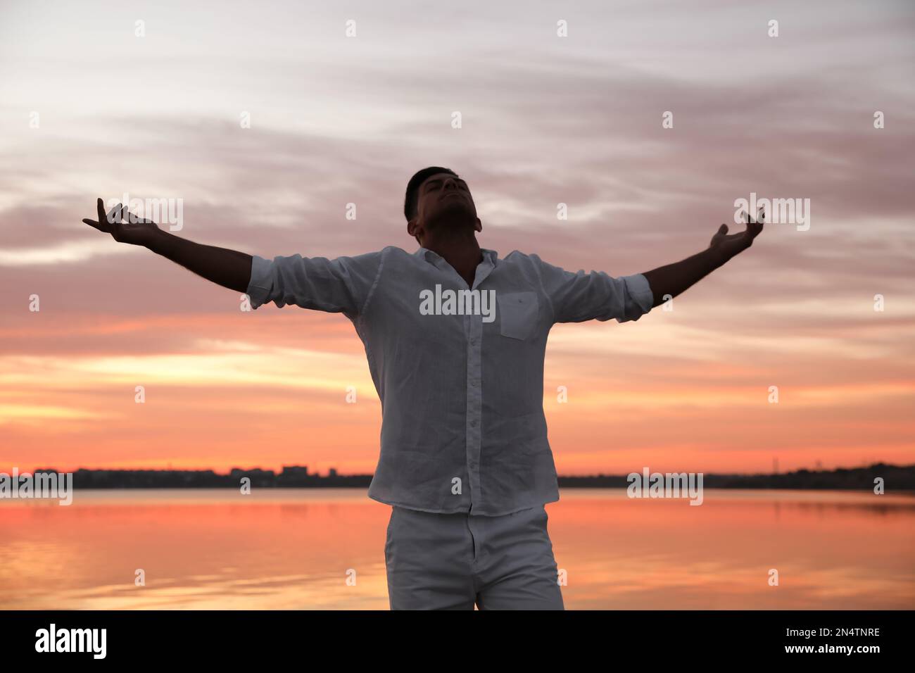 Man near river at sunset. Nature healing power Stock Photo - Alamy