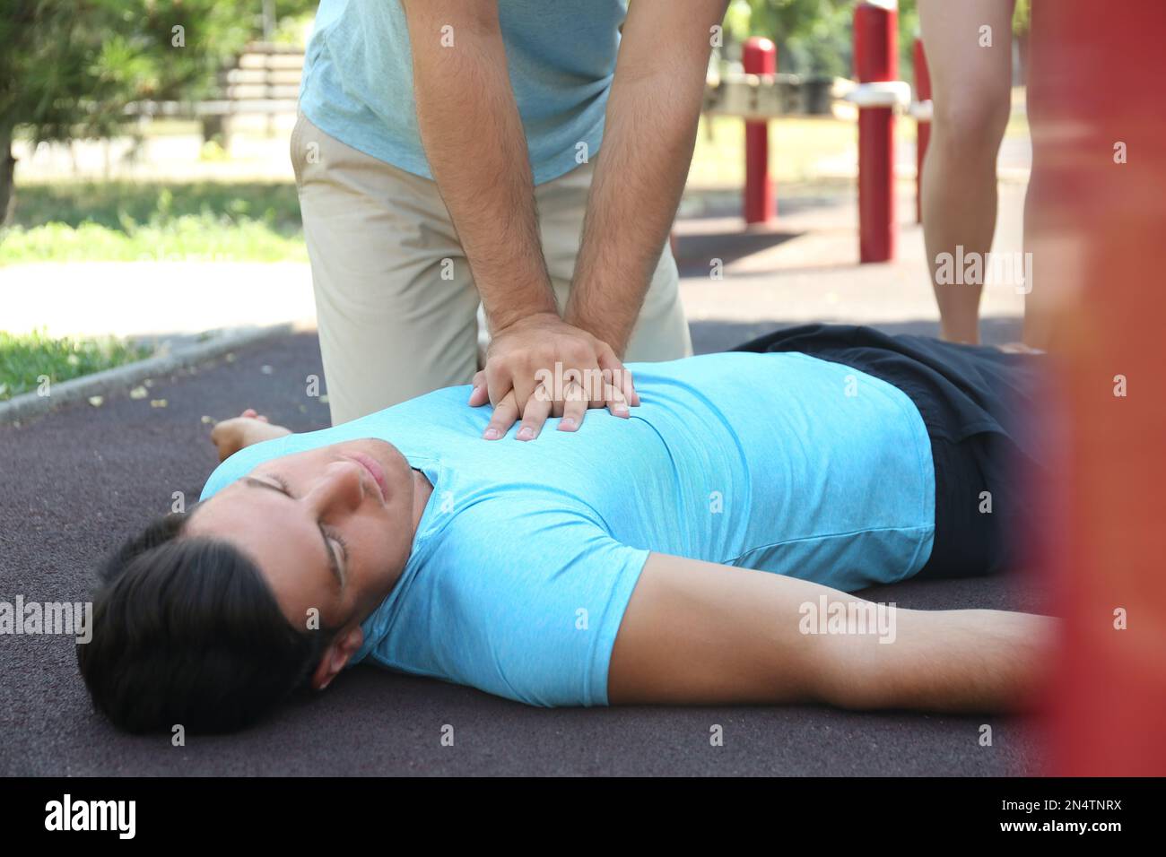 Passerby performing CPR on unconscious man outdoors. First aid Stock ...