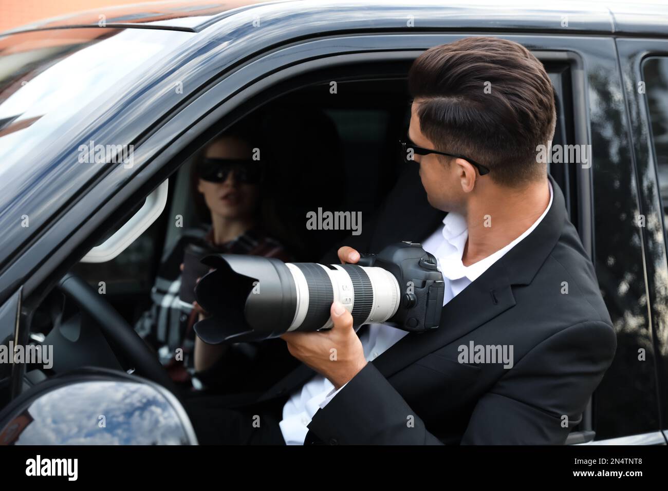 Private detectives with modern camera spying from car Stock Photo - Alamy
