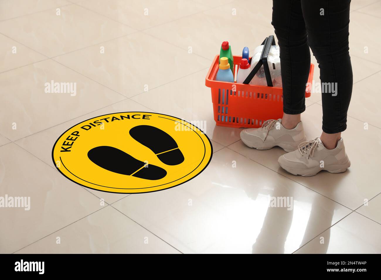 Woman near sign KEEP DISTANCE in supermarket. Coronavirus pandemic ...
