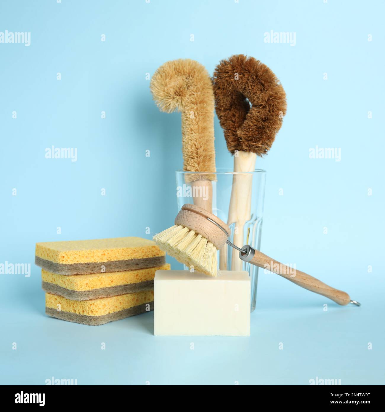 Cleaning supplies for dish washing on light blue background Stock Photo ...