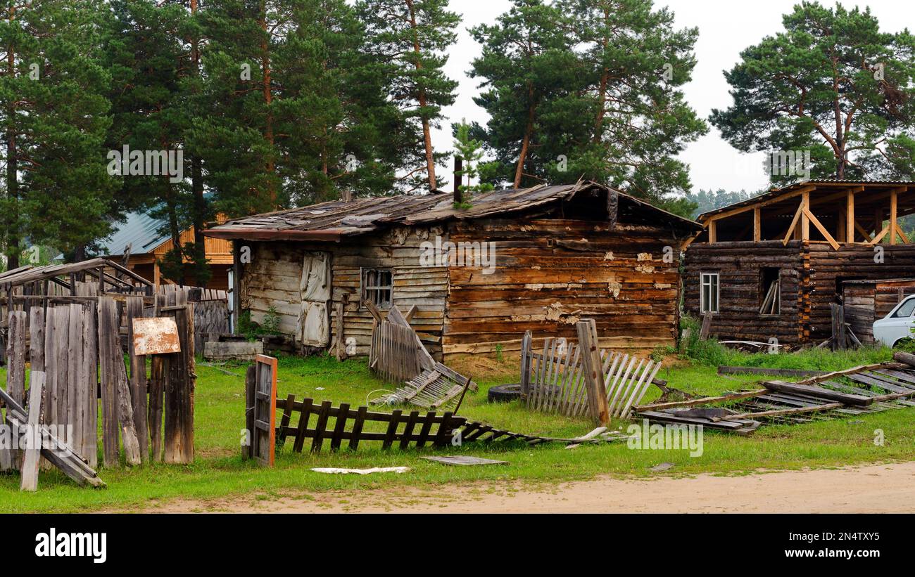 An old, abandoned wooden barn stands behind a fallen fence in the ...