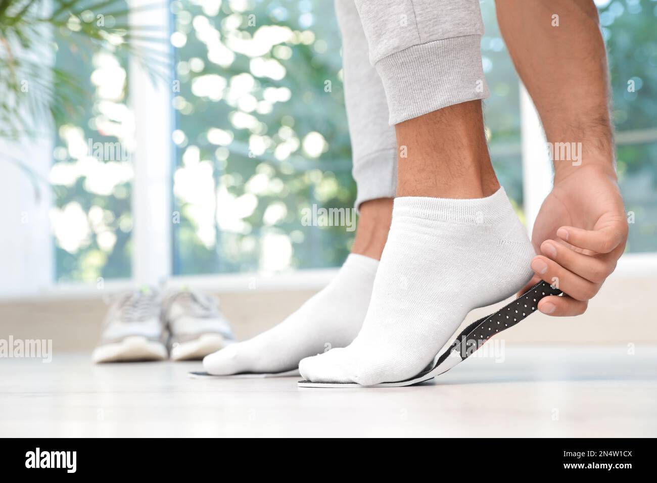 Man fitting orthopedic insole indoors, closeup. Foot care Stock Photo ...