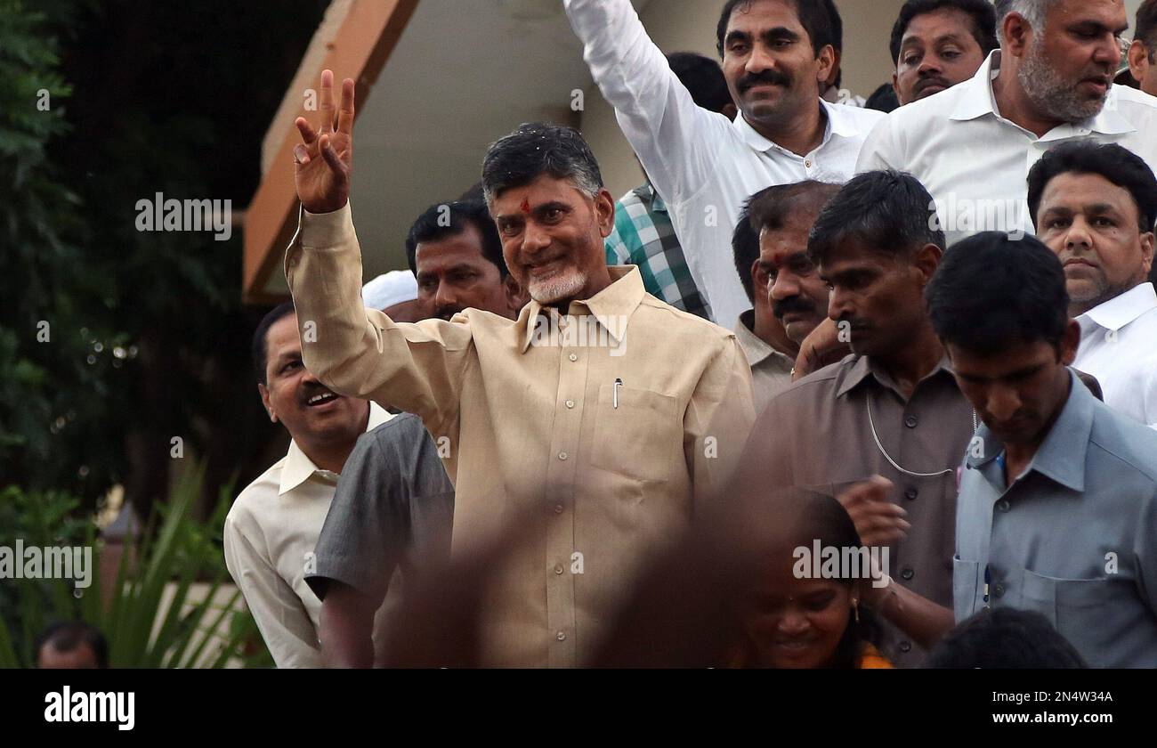 Telugu Desam Party (TDP) President N. Chandrababu Naidu, left, displays the victory symbol to ...