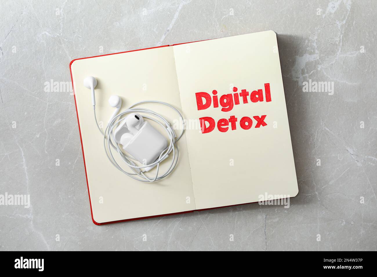 Open notebook with earphones and words DIGITAL DETOX on light grey ...