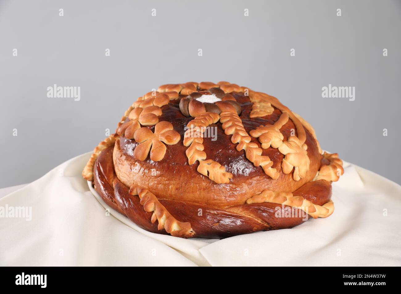 Korovai on tablecloth against grey background. Ukrainian bread and salt ...