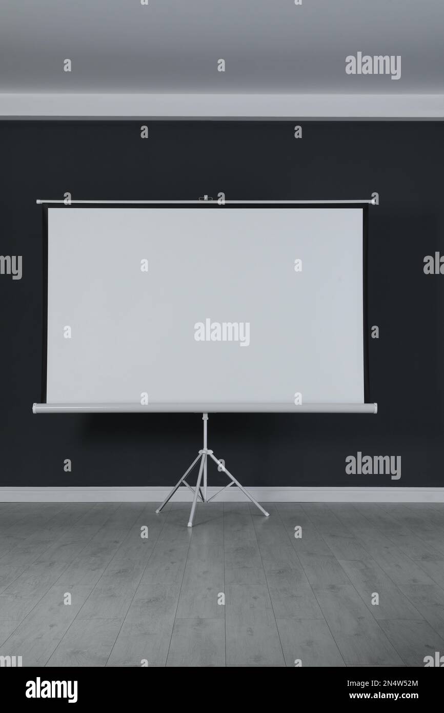 Blank projection screen near black wall indoors. Space for design Stock ...