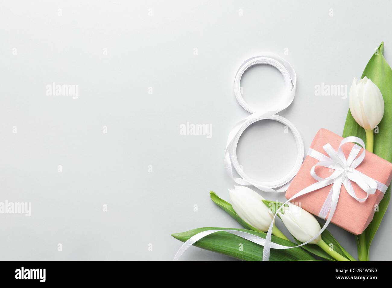 8 March card design with tulips, gift and space for text on light grey ...