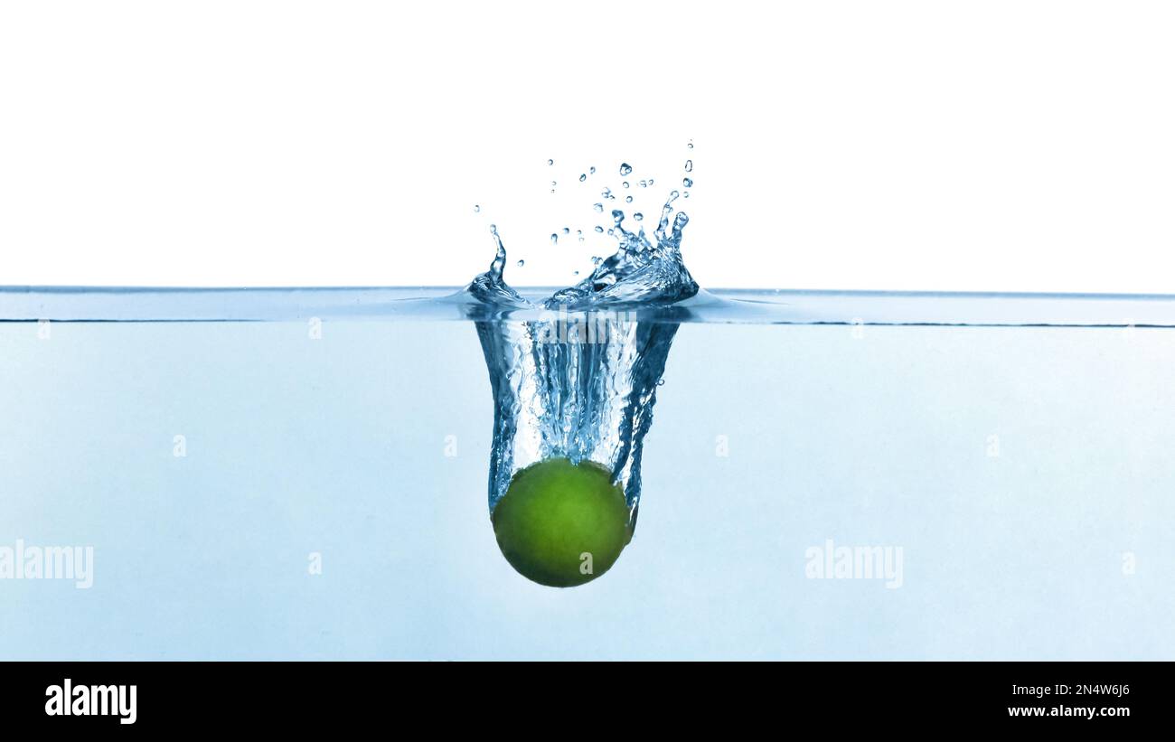 Lime falling down into clear water against white background Stock Photo ...
