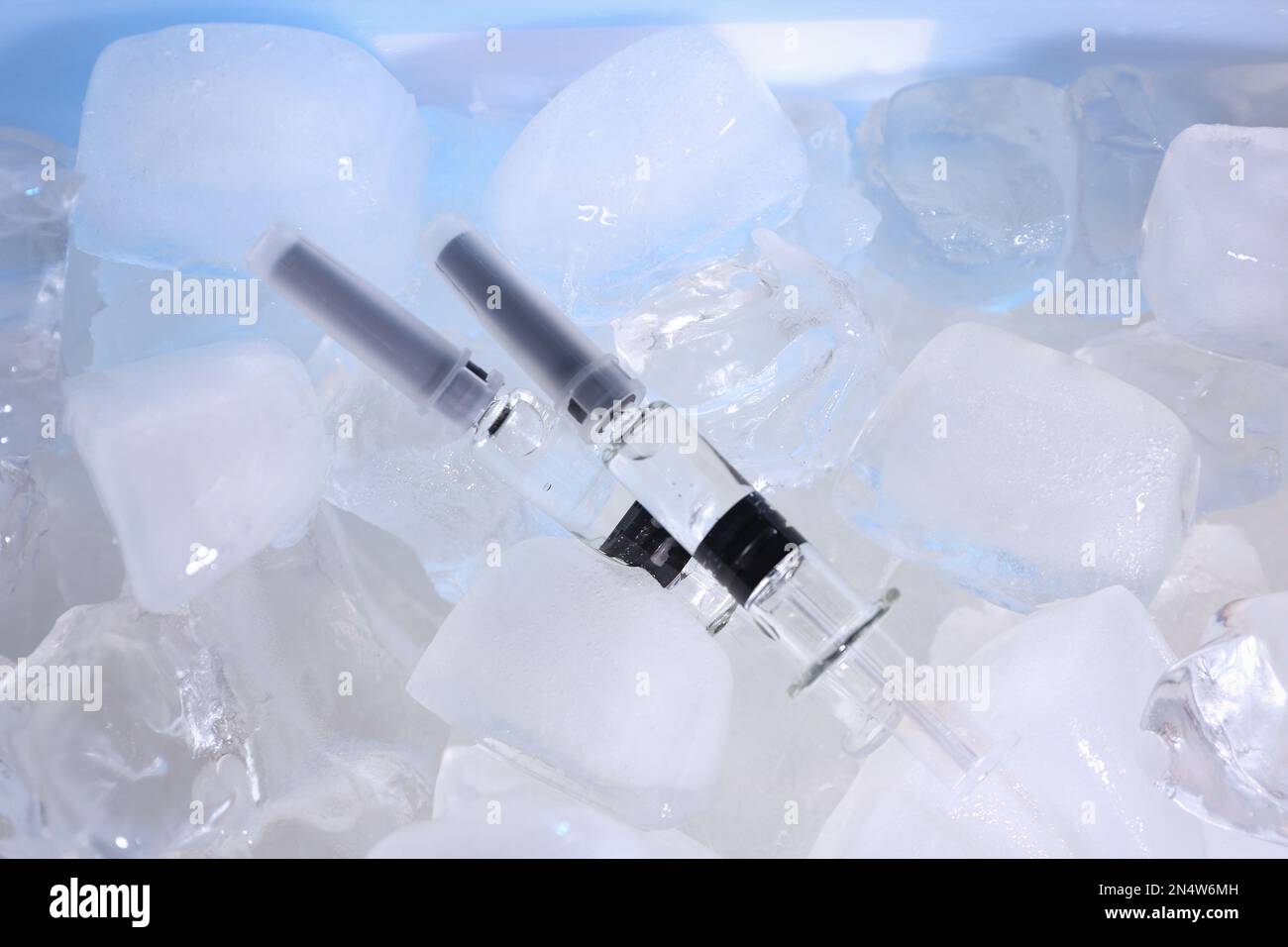 Syringes with COVID-19 vaccine on ice cubes Stock Photo - Alamy